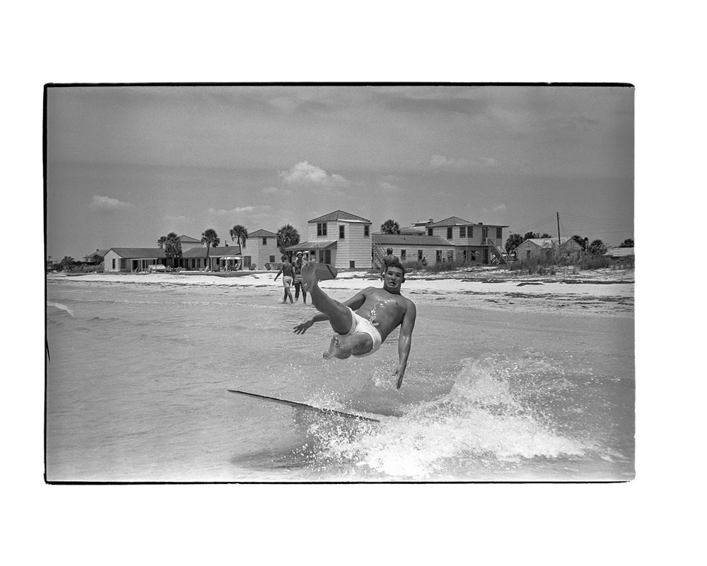 Man with a shortboard doing tricks in the shallow surf, Florida, 1964 ...